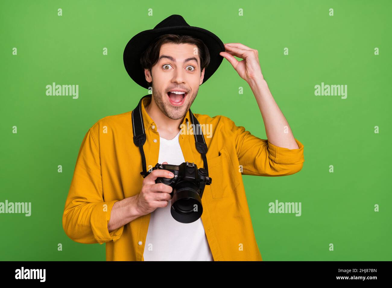 Portrait of young good looking positive amazed photographer hold camera ...