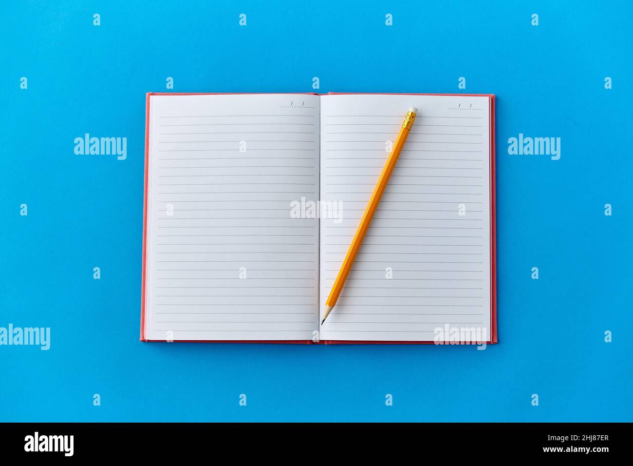 open notebook with pencil on blue background Stock Photo - Alamy
