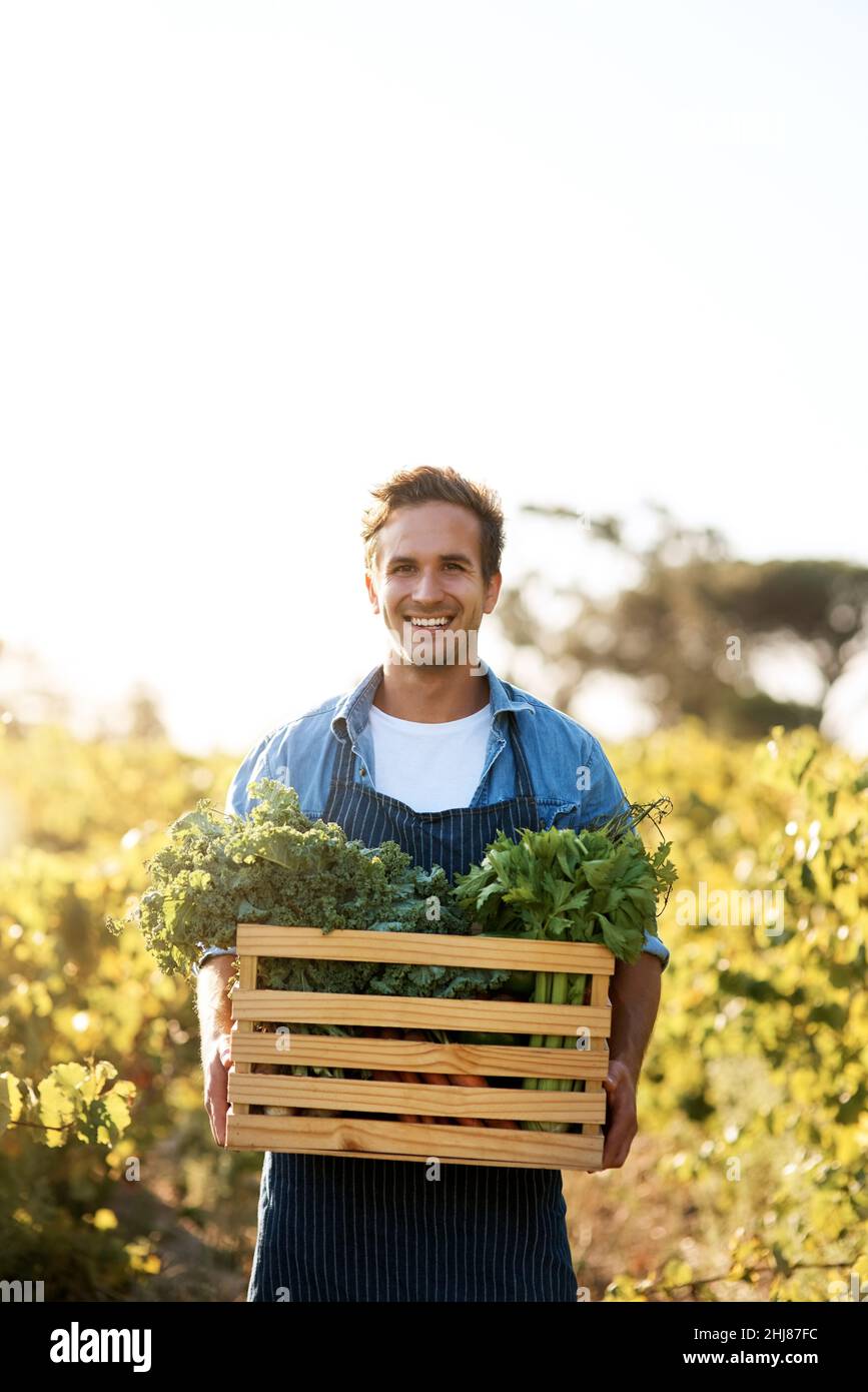 Know where your food come from. Shot of a young man holding a crate ...