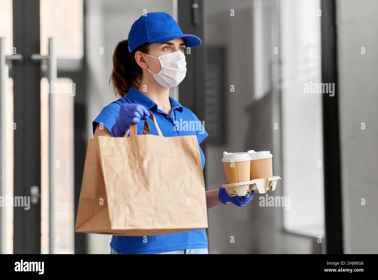 delivery woman in face mask with food and drinks Stock Photo - Alamy