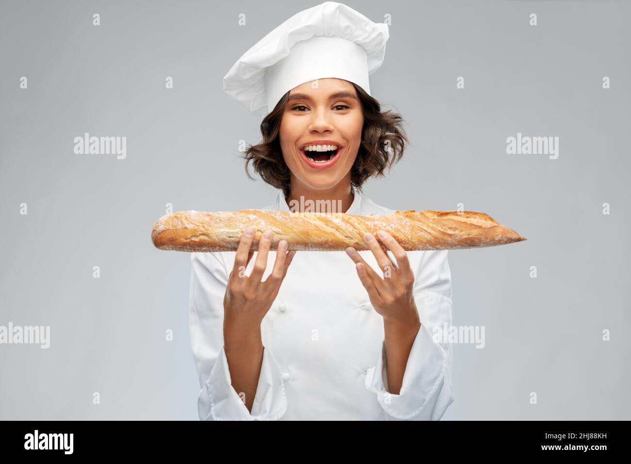 happy female chef with french bread or baguette Stock Photo - Alamy
