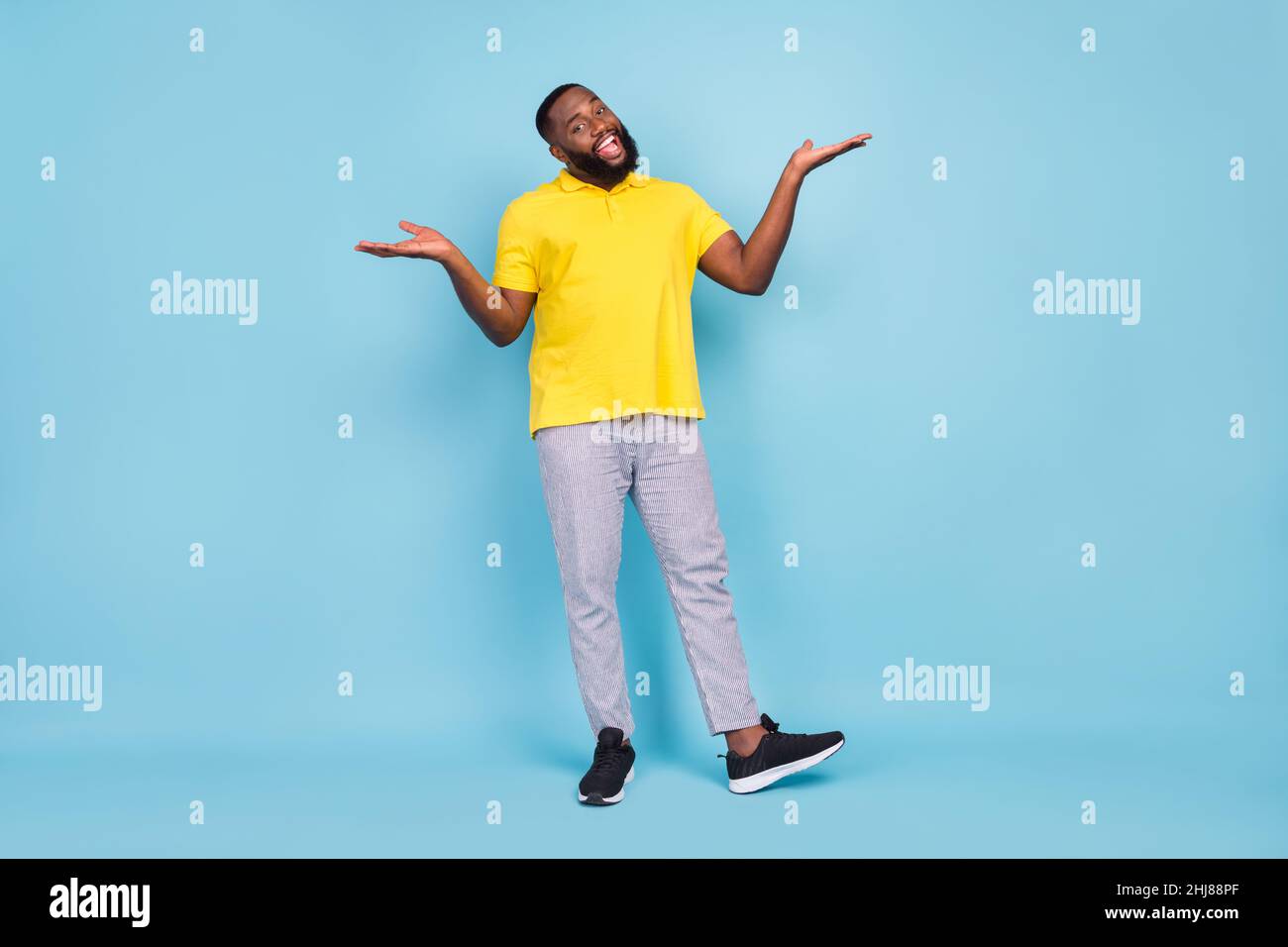 Photo of sweet excited dark skin guy dressed yellow t-shirt shrugging ...