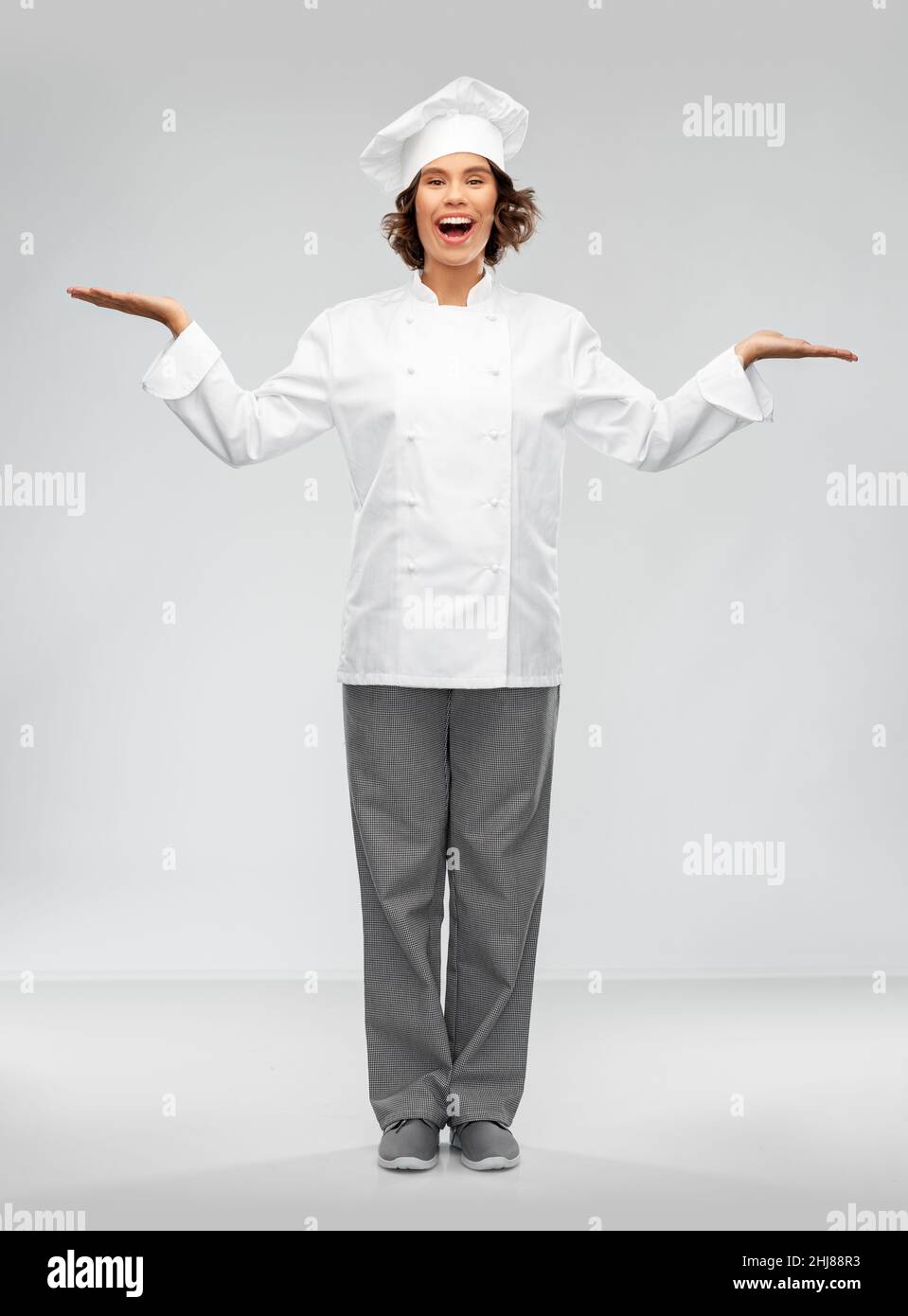 smiling female chef holding something on hand Stock Photo - Alamy
