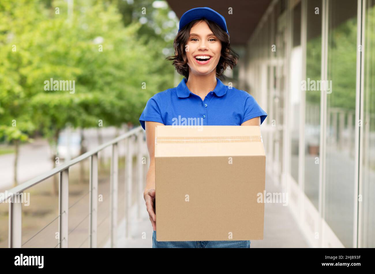 happy delivery girl with parcel box in blue Stock Photo - Alamy