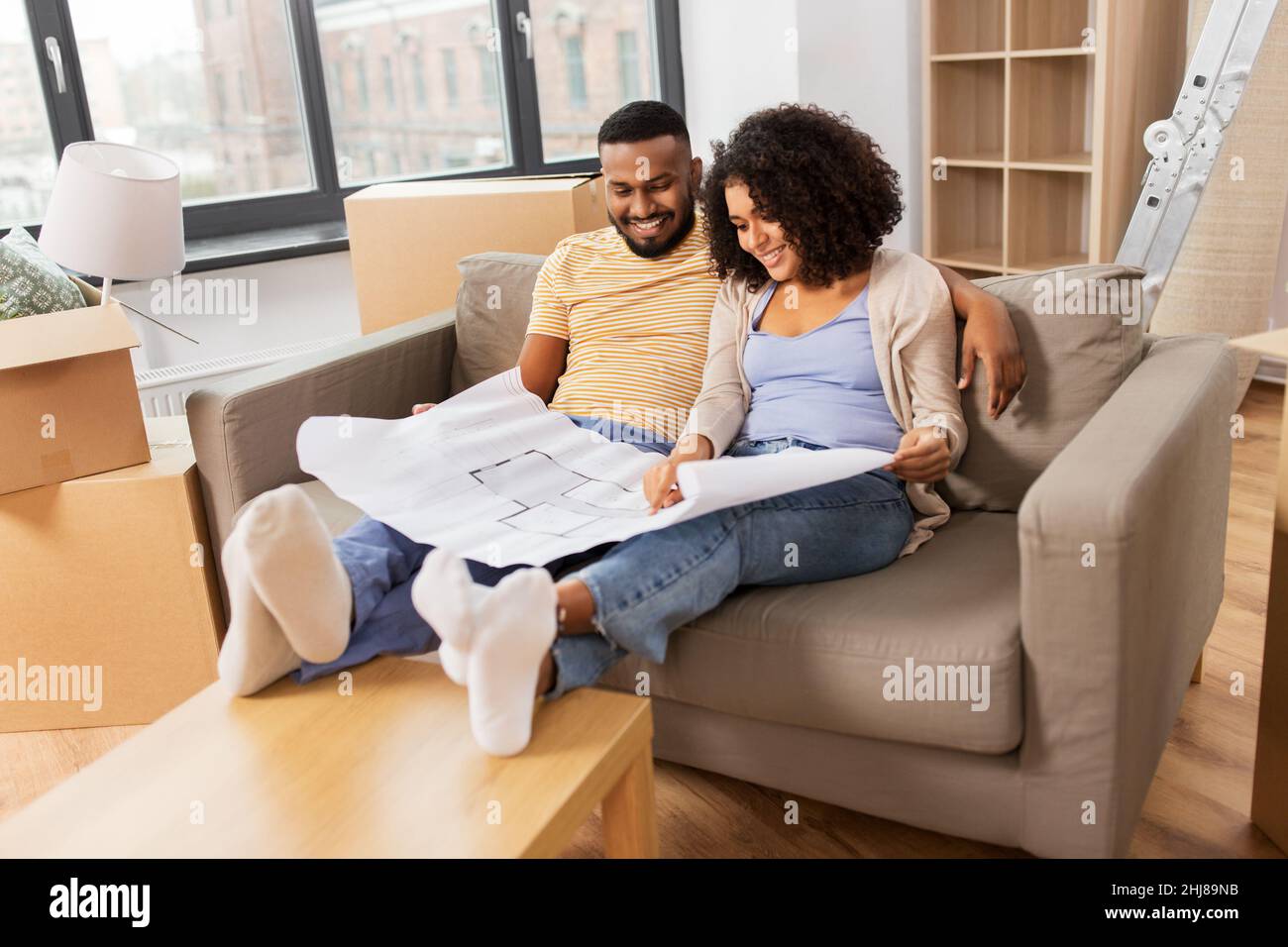 couple with boxes and blueprint moving to new home Stock Photo - Alamy