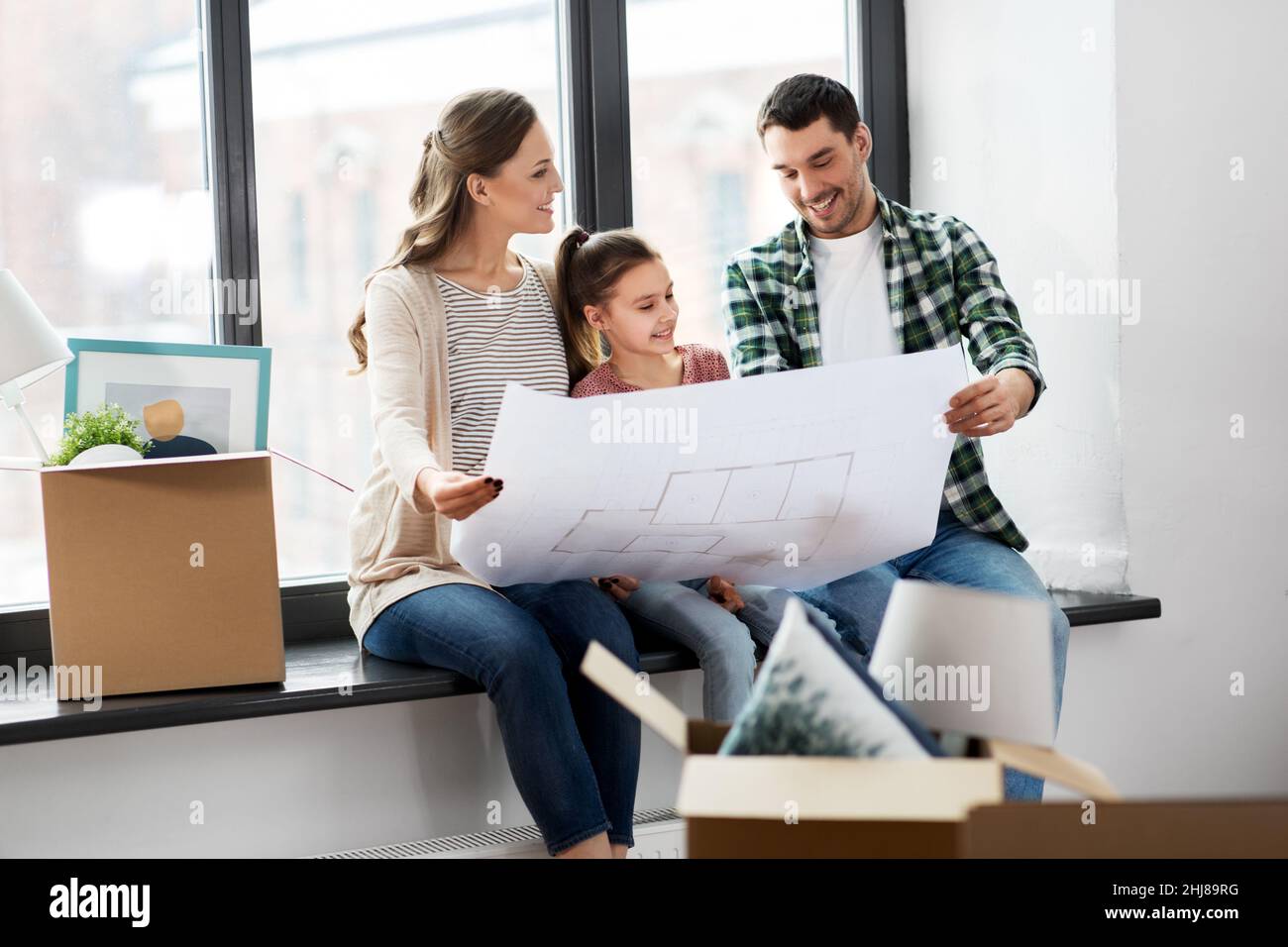 happy family with blueprint moving to new home Stock Photo - Alamy
