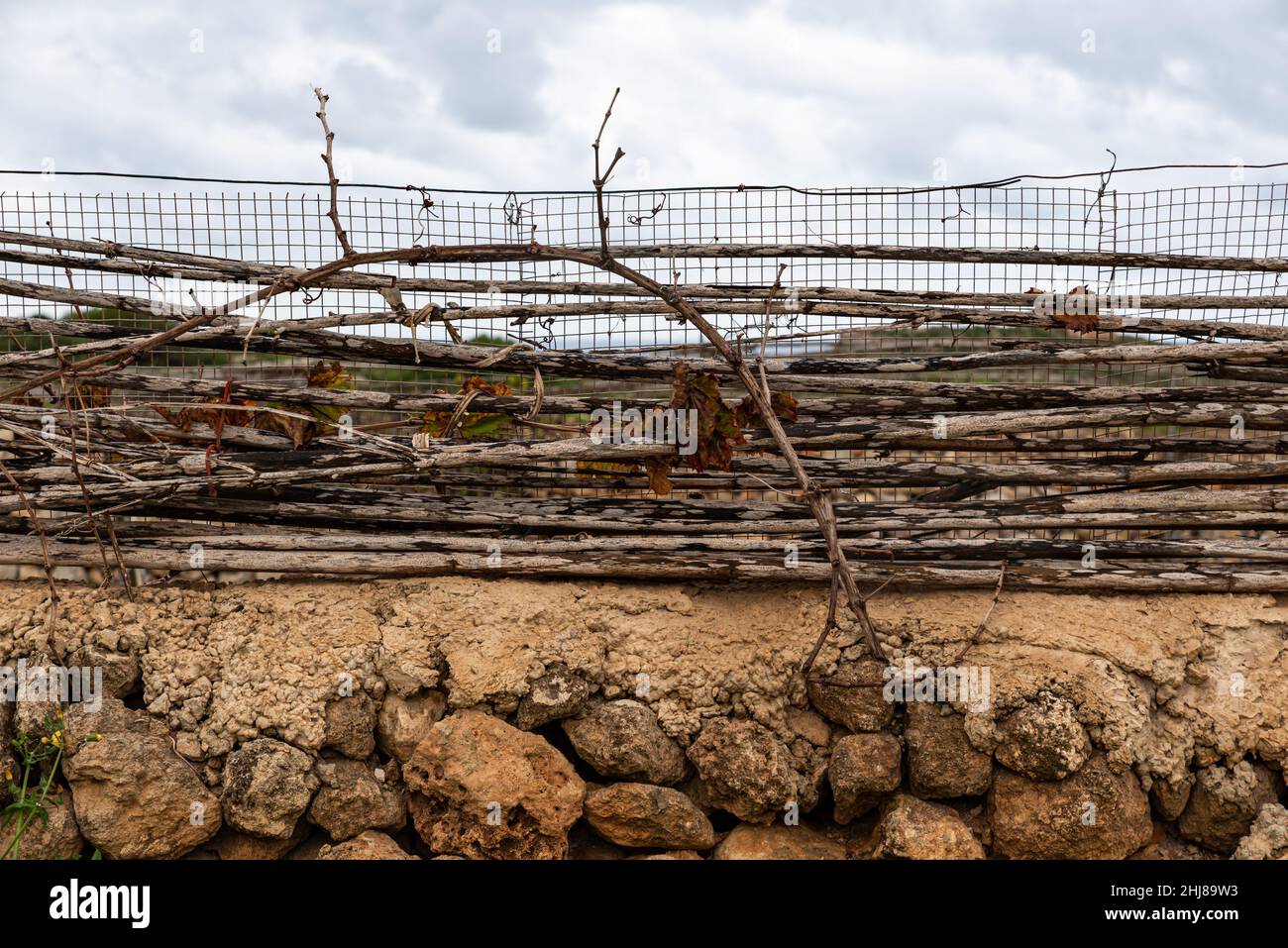 Traditional yellow brown nature stone wall of farmers with a wooden ...