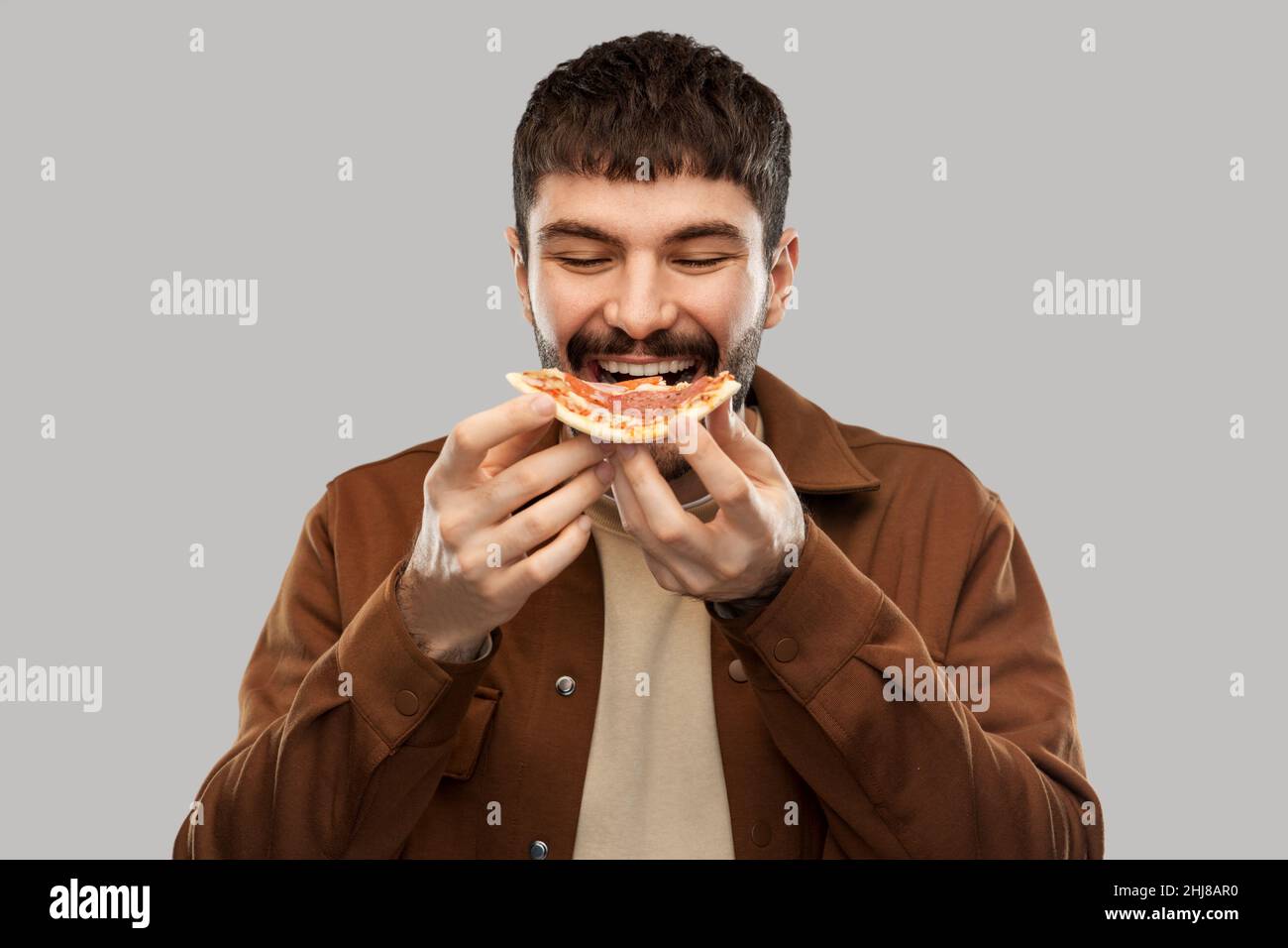 happy smiling young man eating pizza Stock Photo - Alamy