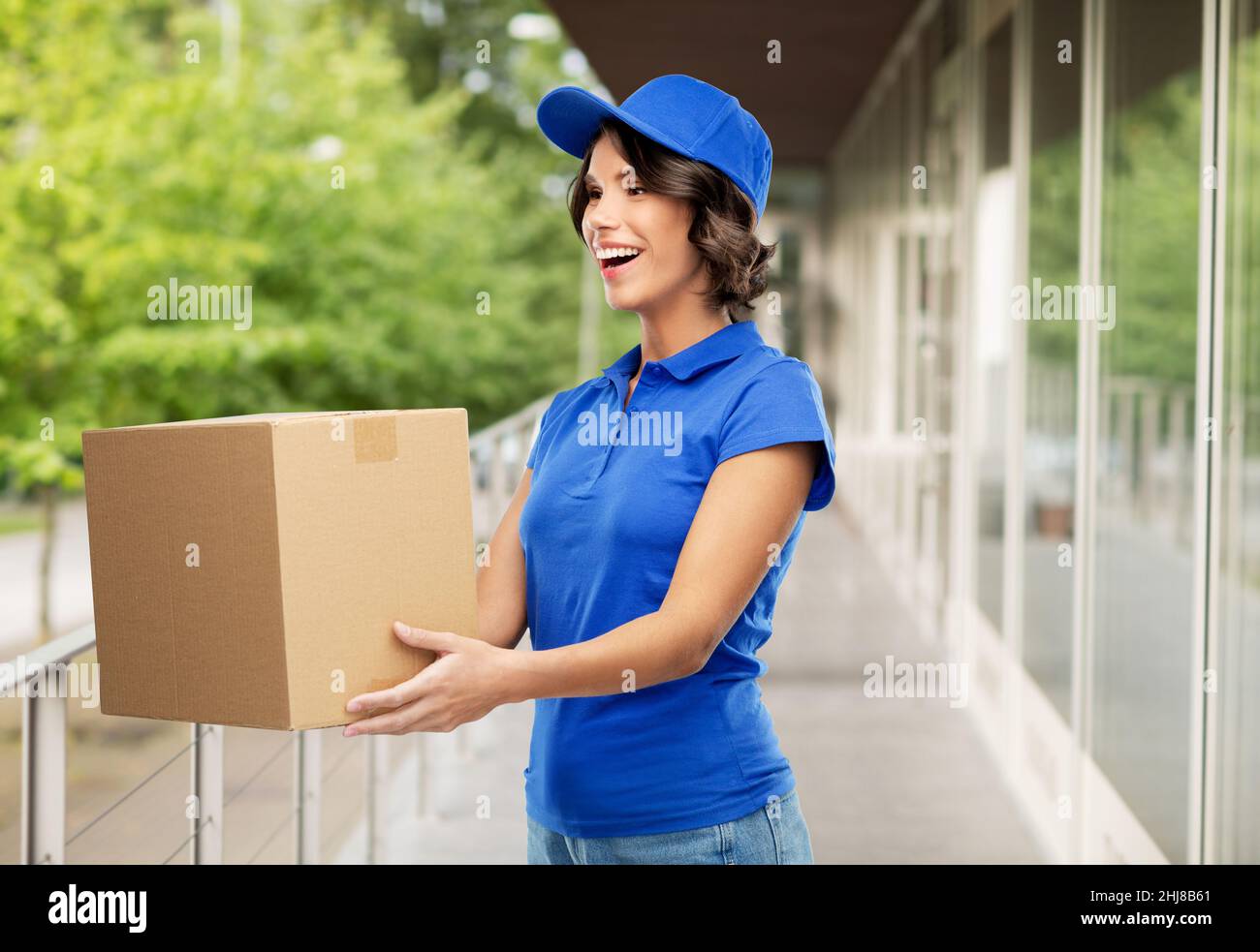 happy delivery girl with parcel box in blue Stock Photo - Alamy