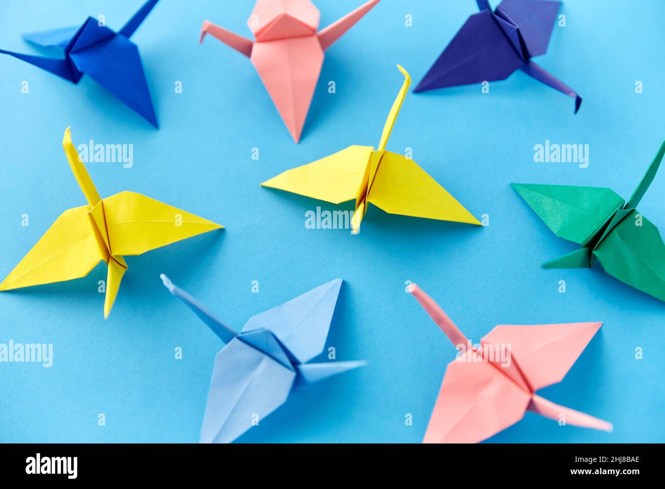 origami paper cranes on blue background Stock Photo - Alamy