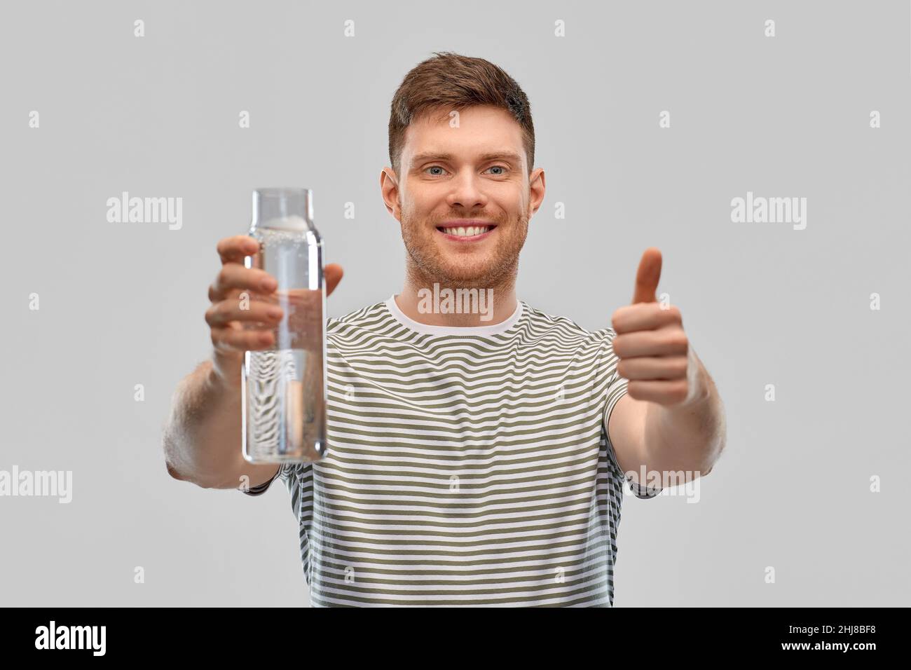 happy smiling man holding water in glass bottle Stock Photo - Alamy