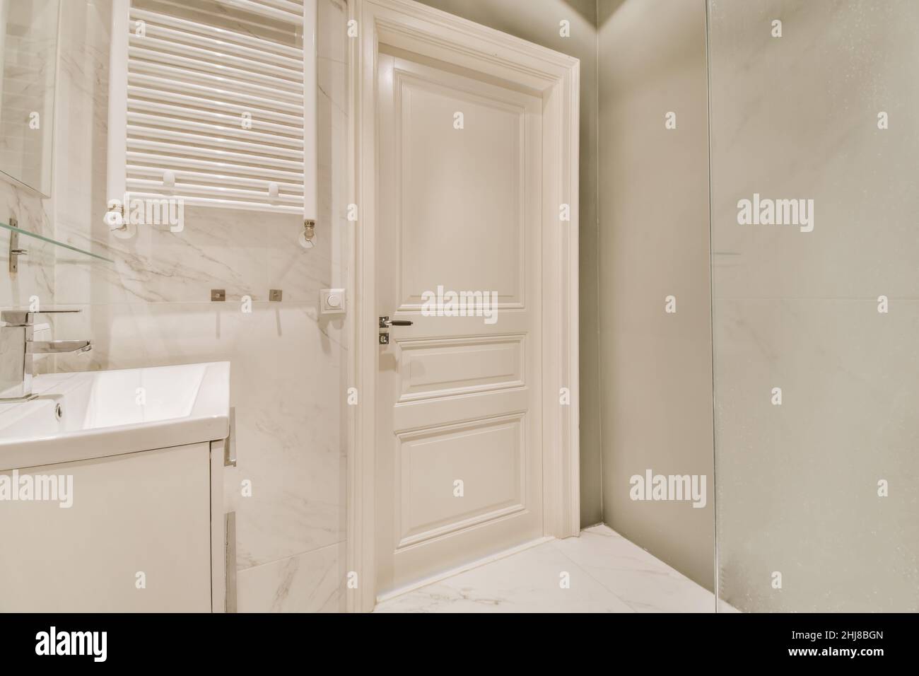 Bright bathroom with a hanging radiator next to the door Stock Photo ...