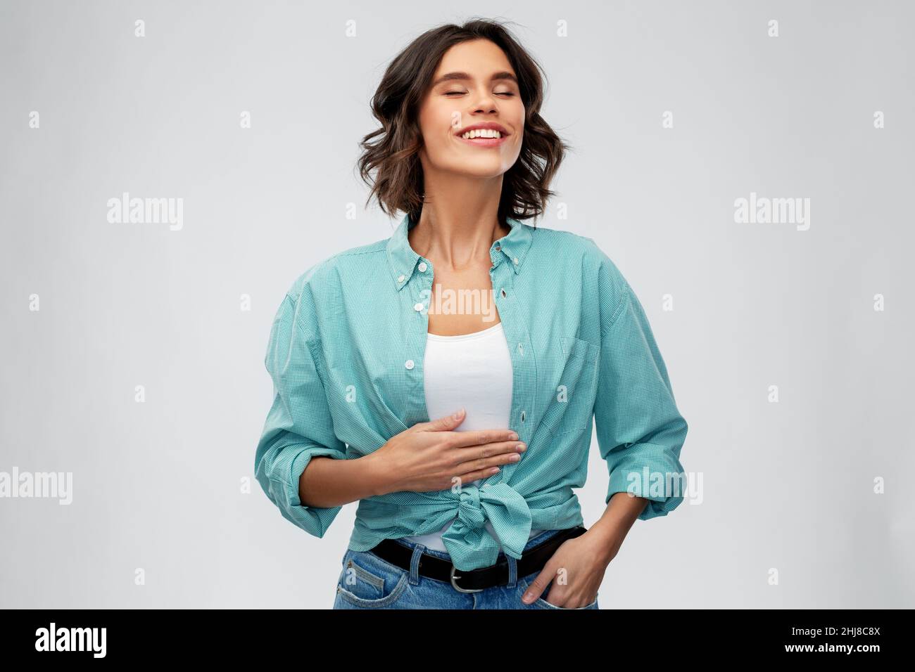 happy full young woman touching her tummy Stock Photo - Alamy