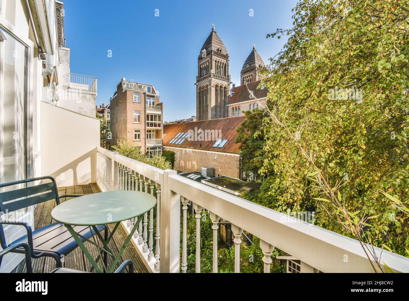 Cozy long narrow balcony with small table and chairs Stock Photo - Alamy