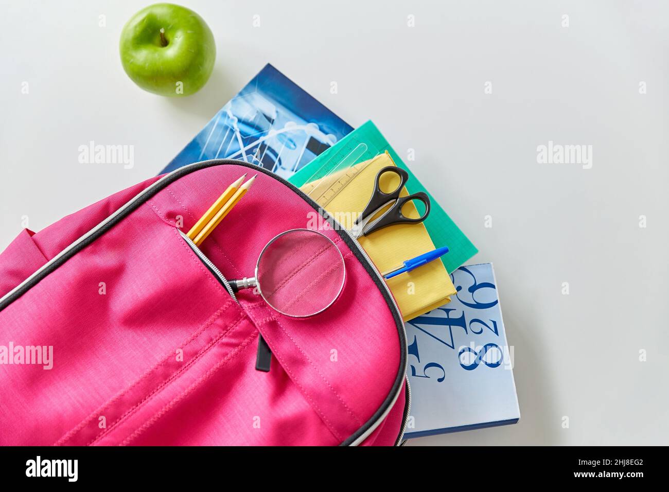 backpack with books, school supplies and apple Stock Photo - Alamy