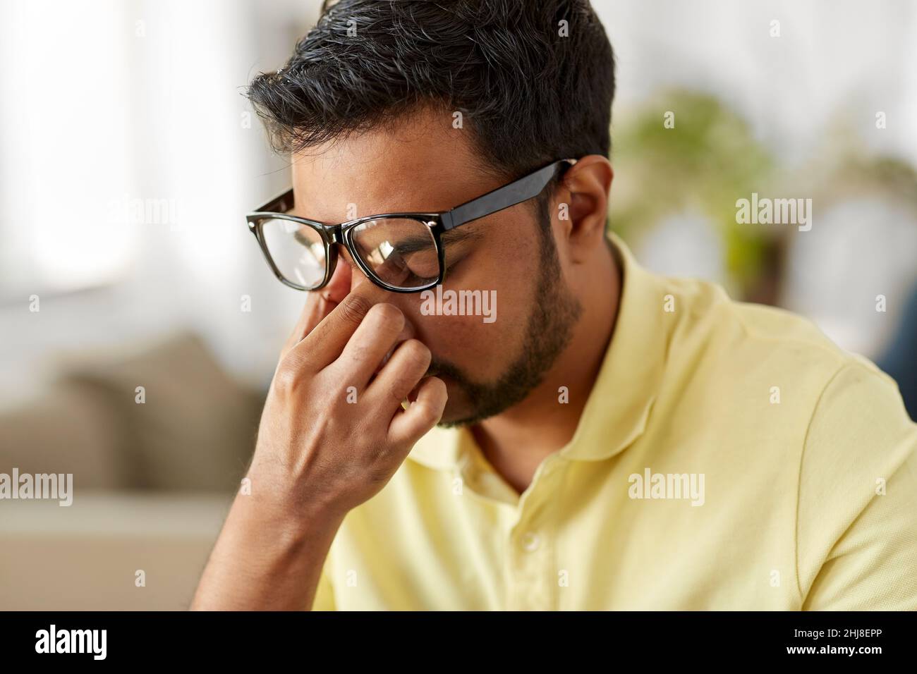 tired man rubbing his nose bridge at home Stock Photo - Alamy