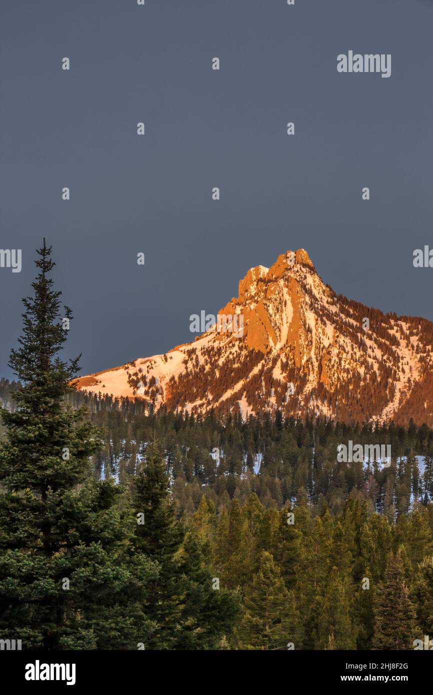 first light on ross peak in the bridger range against a dark winter sky ...