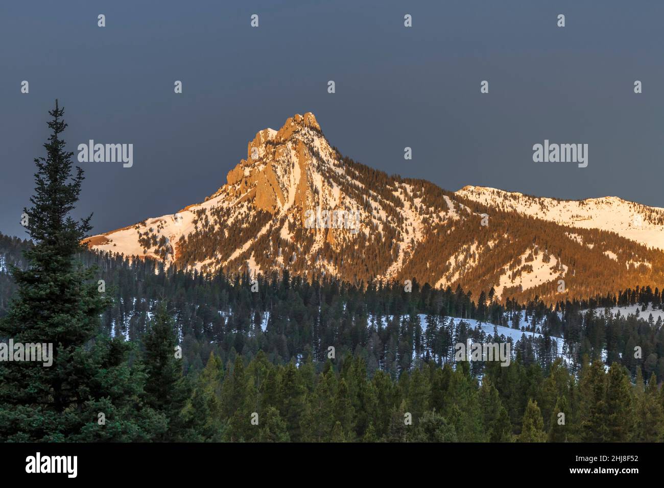 first light on ross peak in the bridger range against a dark winter sky ...
