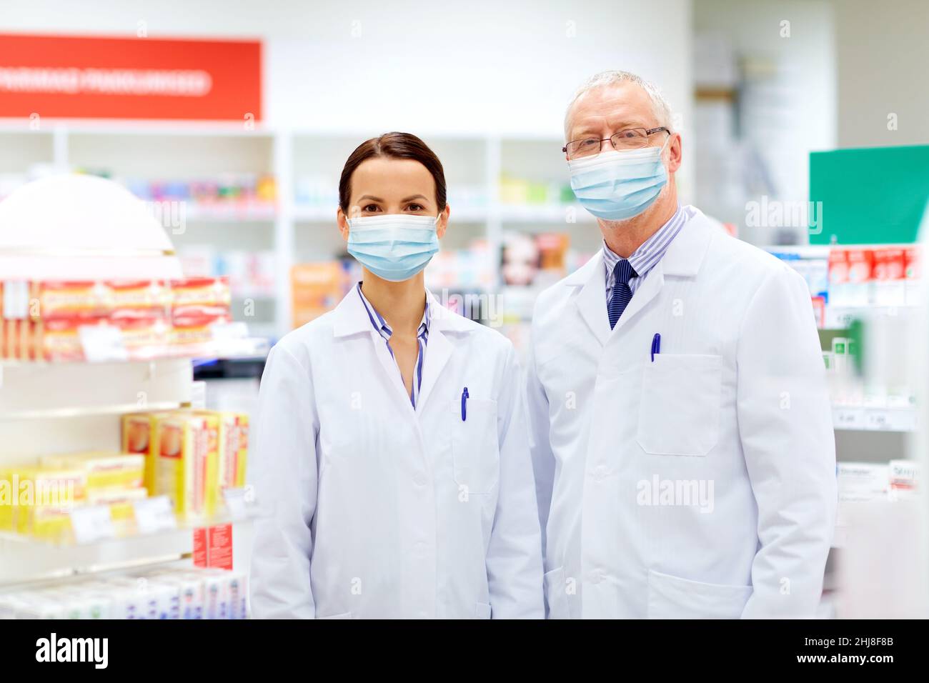 apothecaries wearing medical masks at pharmacy Stock Photo - Alamy