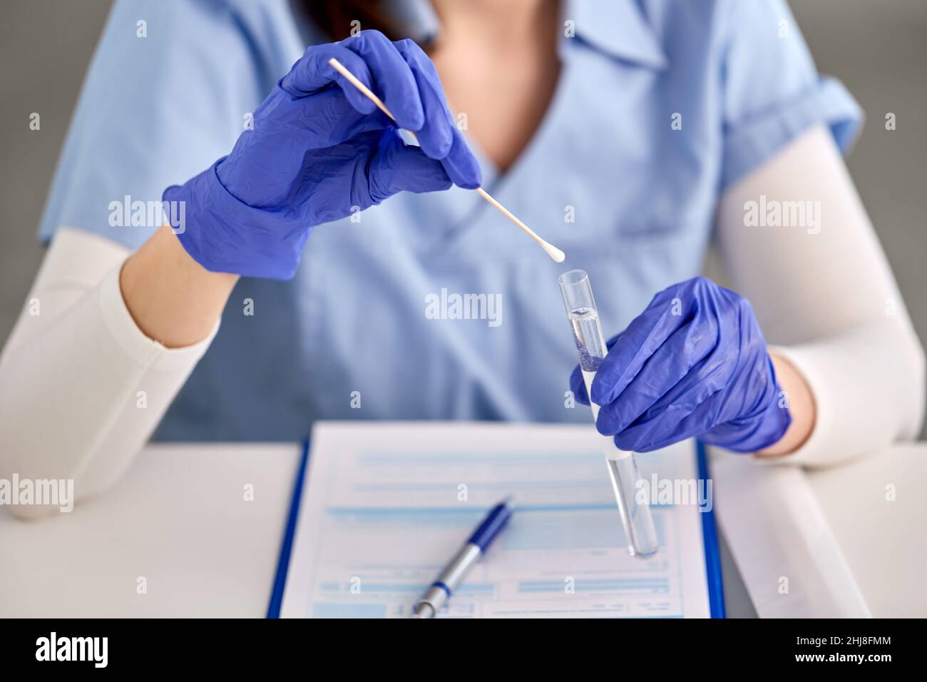 hands in gloves holding test tube and cotton swab Stock Photo - Alamy
