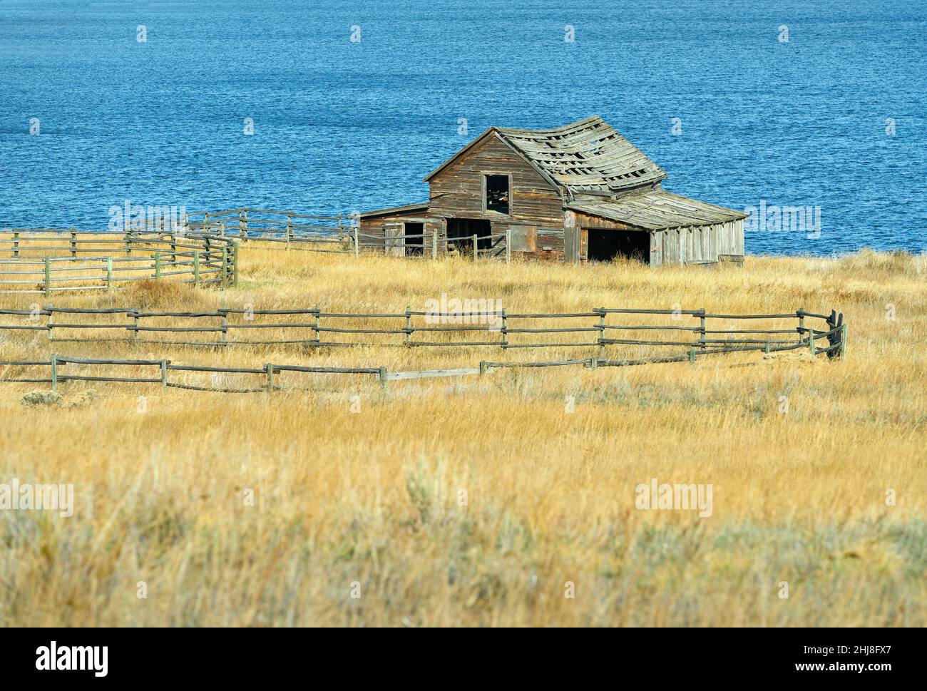 Rustic Barn on Lake. A faded ranch barn next to a lake Stock Photo - Alamy