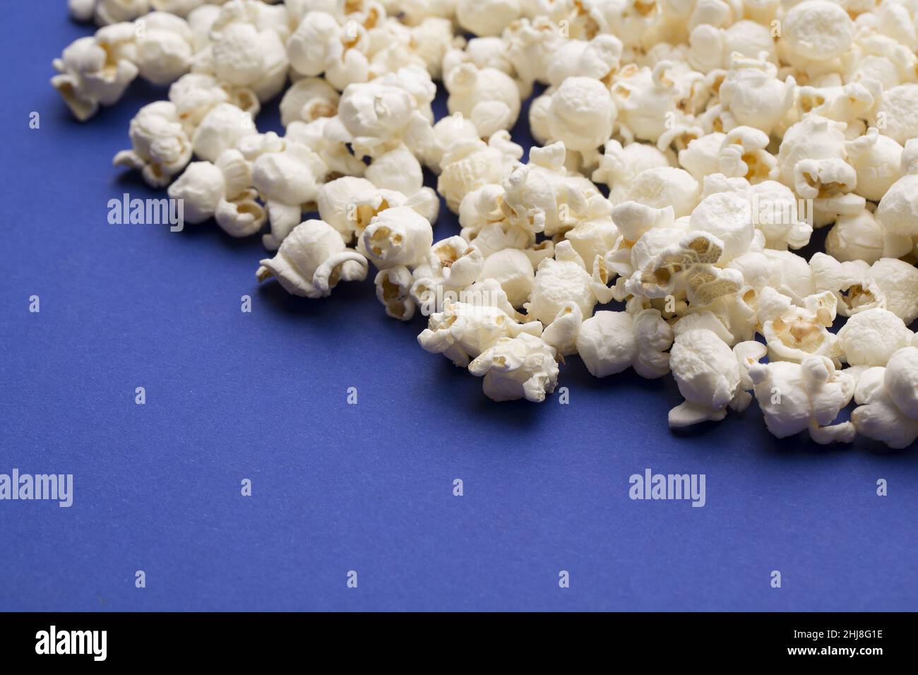 Popcorn on blue background Stock Photo - Alamy