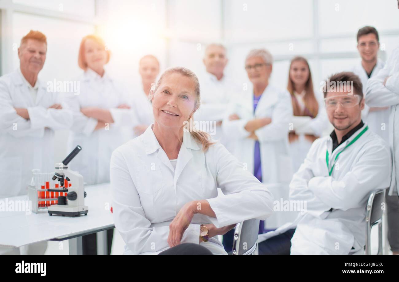 research supervisor and a group of young scientists in the workplace ...