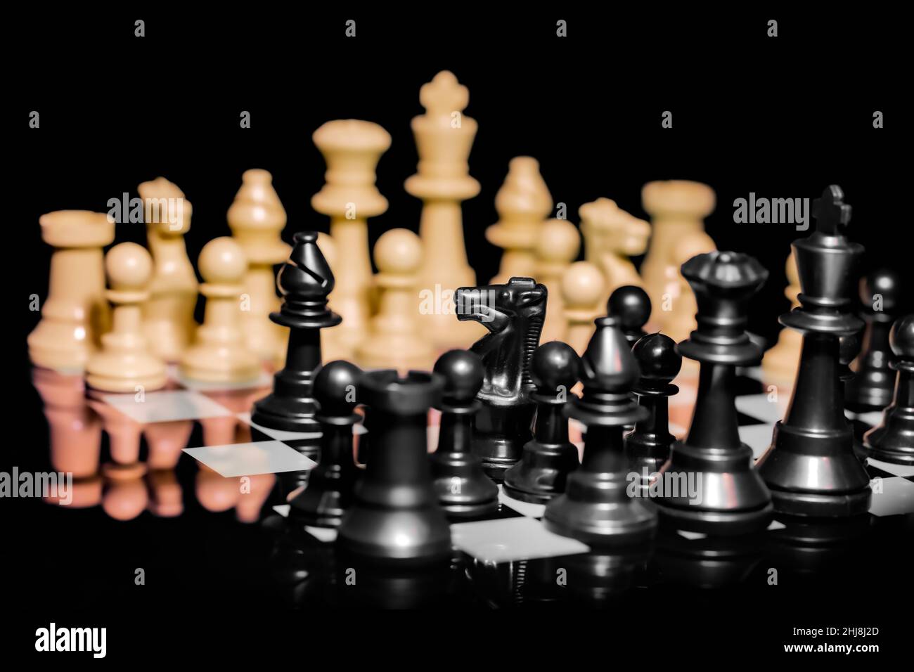 Close up of Chess pieces on a reflective mirror board surface with a ...