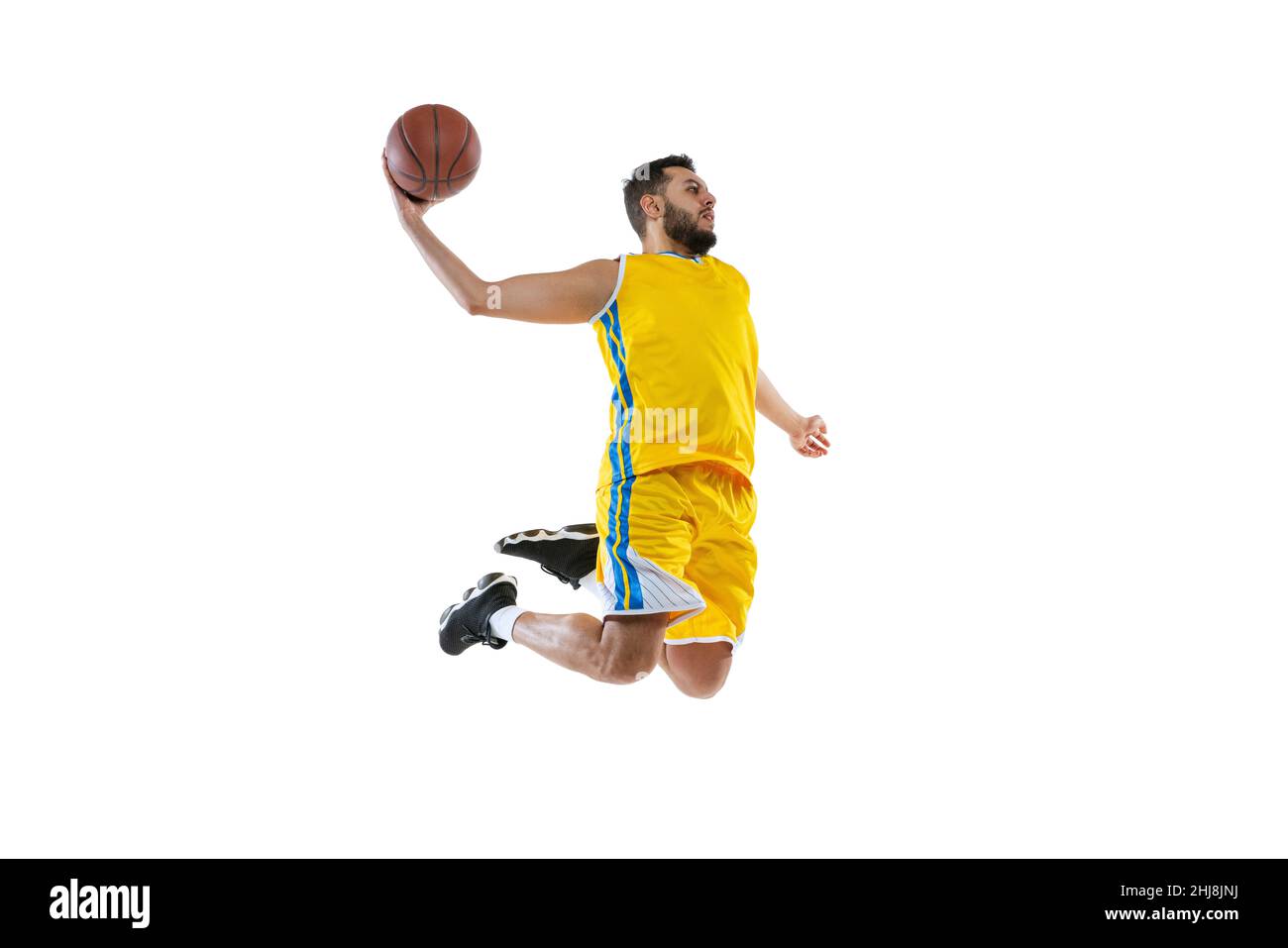 Young sportive man, professional basketball player jumping with ball ...