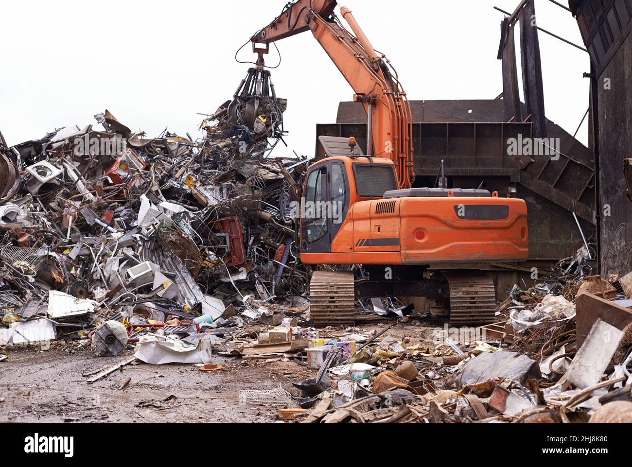 The scrapyard. Cropped shot of an excavator sorting through a pile of ...