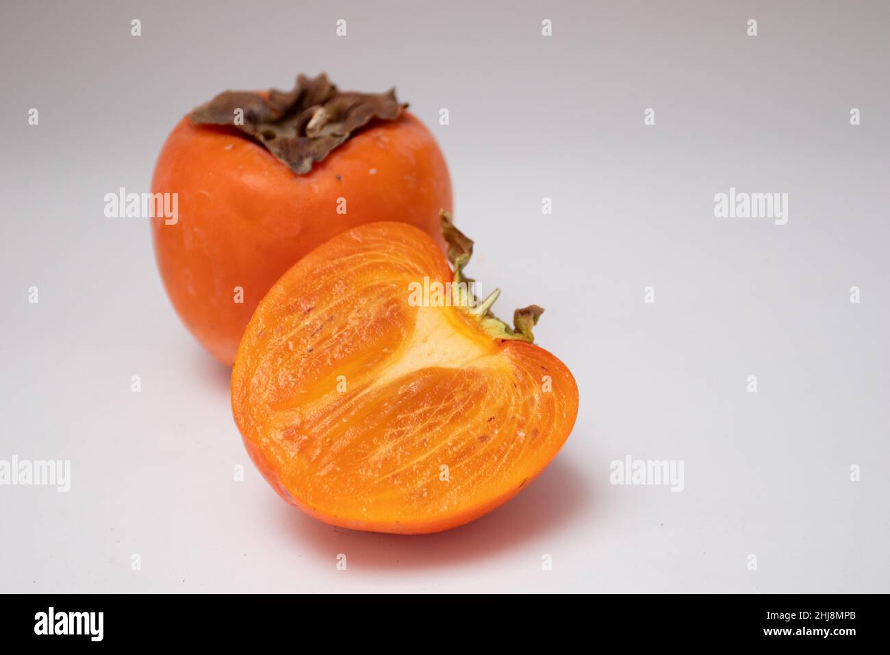 Whole of fresh persimmons and half of persimmons isolated on white ...