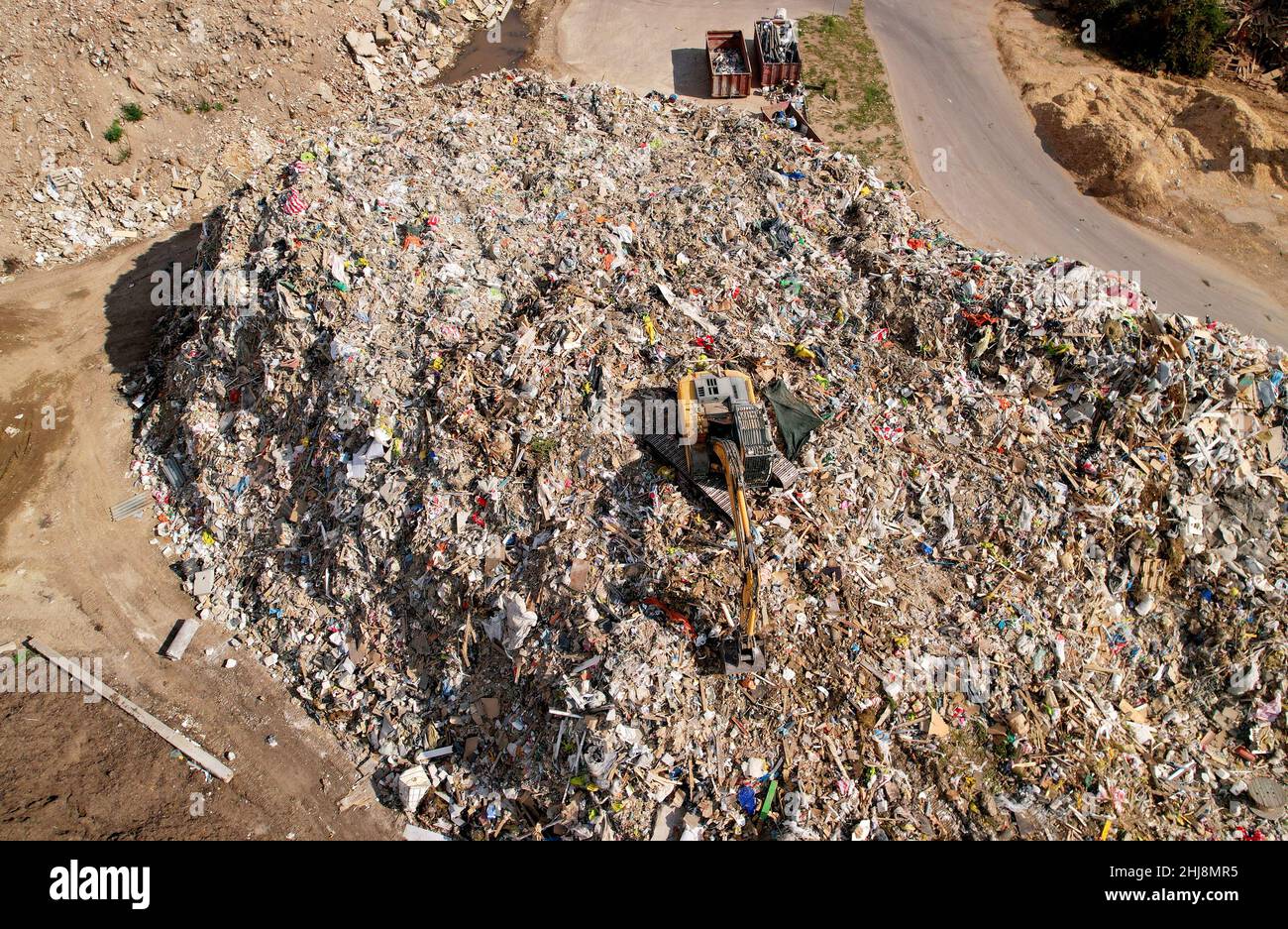 Garbage dump with construction waste. Excavator during recycling of ...