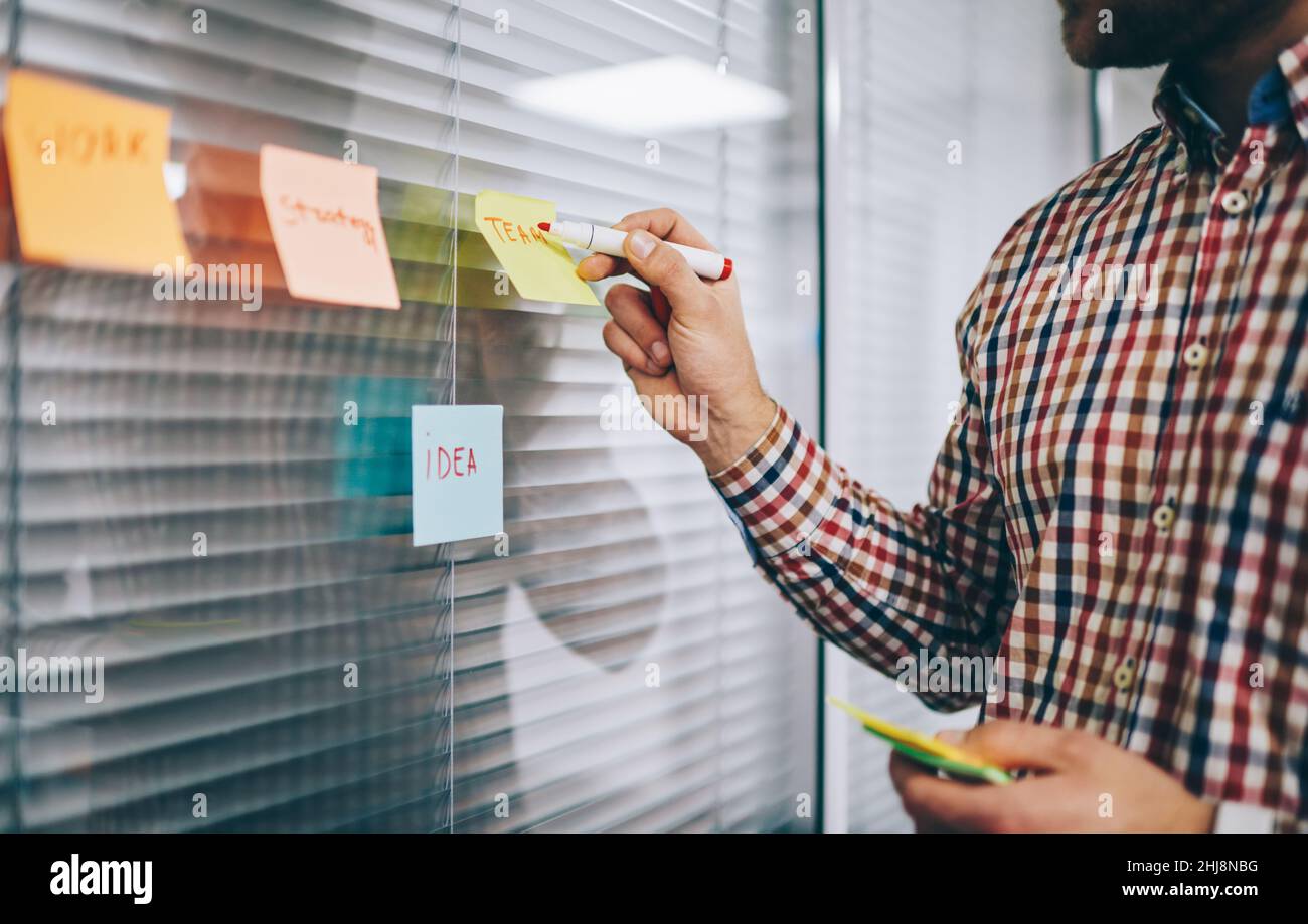 Unrecognizable male employee taking notes on sticky paper Stock Photo ...
