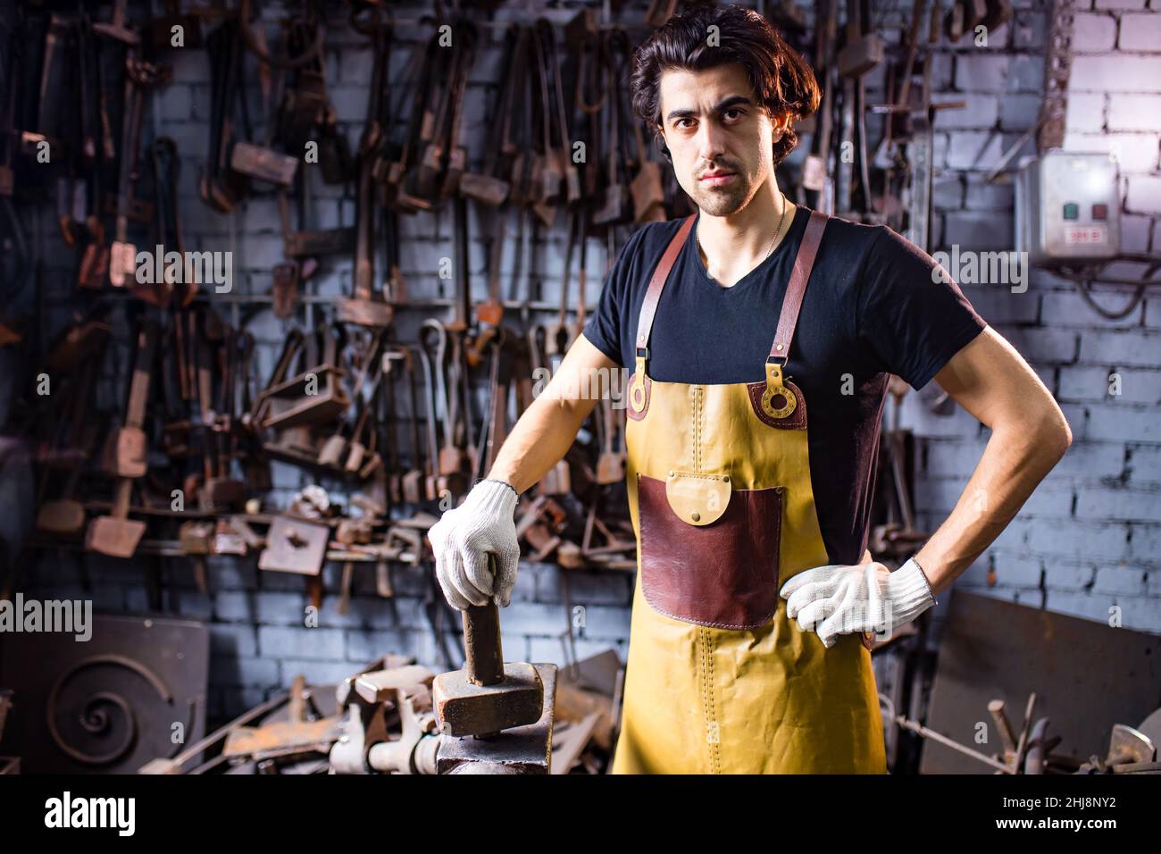 italian brunette man blacksmith working in the workshop Stock Photo - Alamy