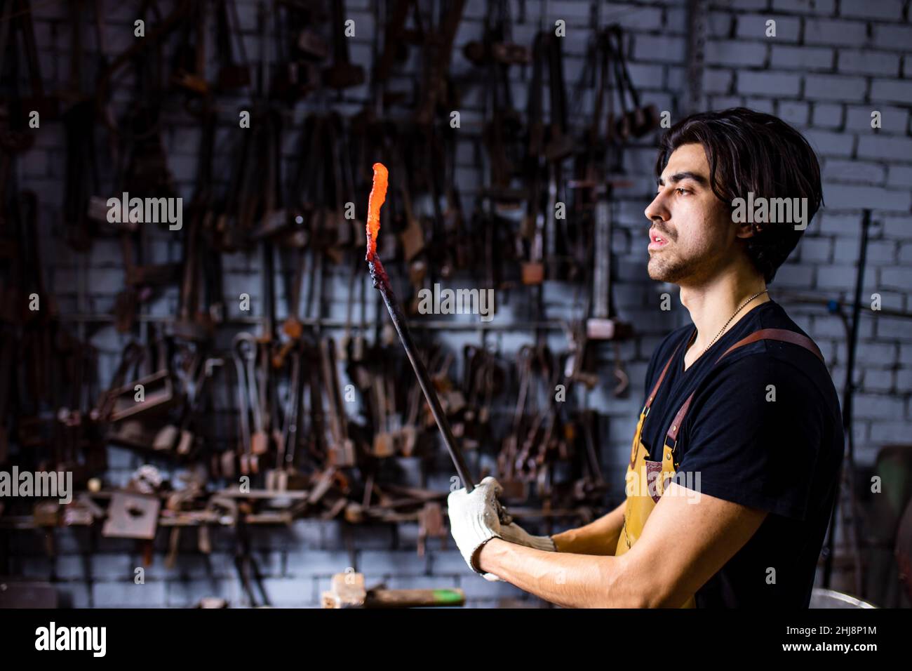 italian brunette man blacksmith working in the workshop Stock Photo - Alamy