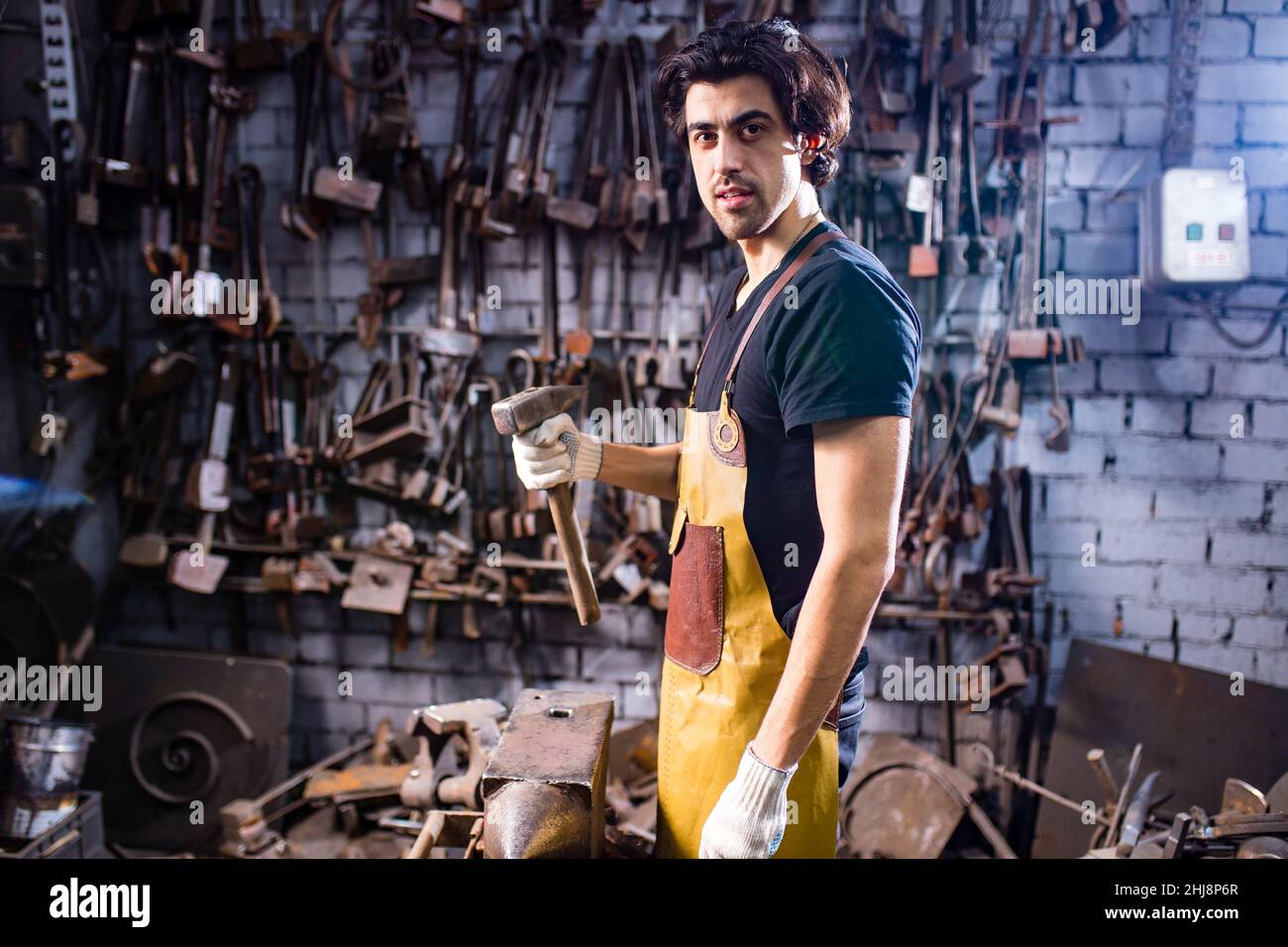italian brunette man blacksmith working in the workshop Stock Photo - Alamy