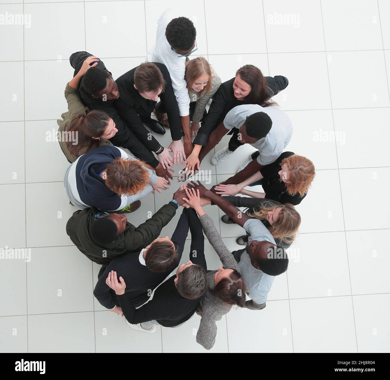 group of young successful people stands around hands together Stock ...