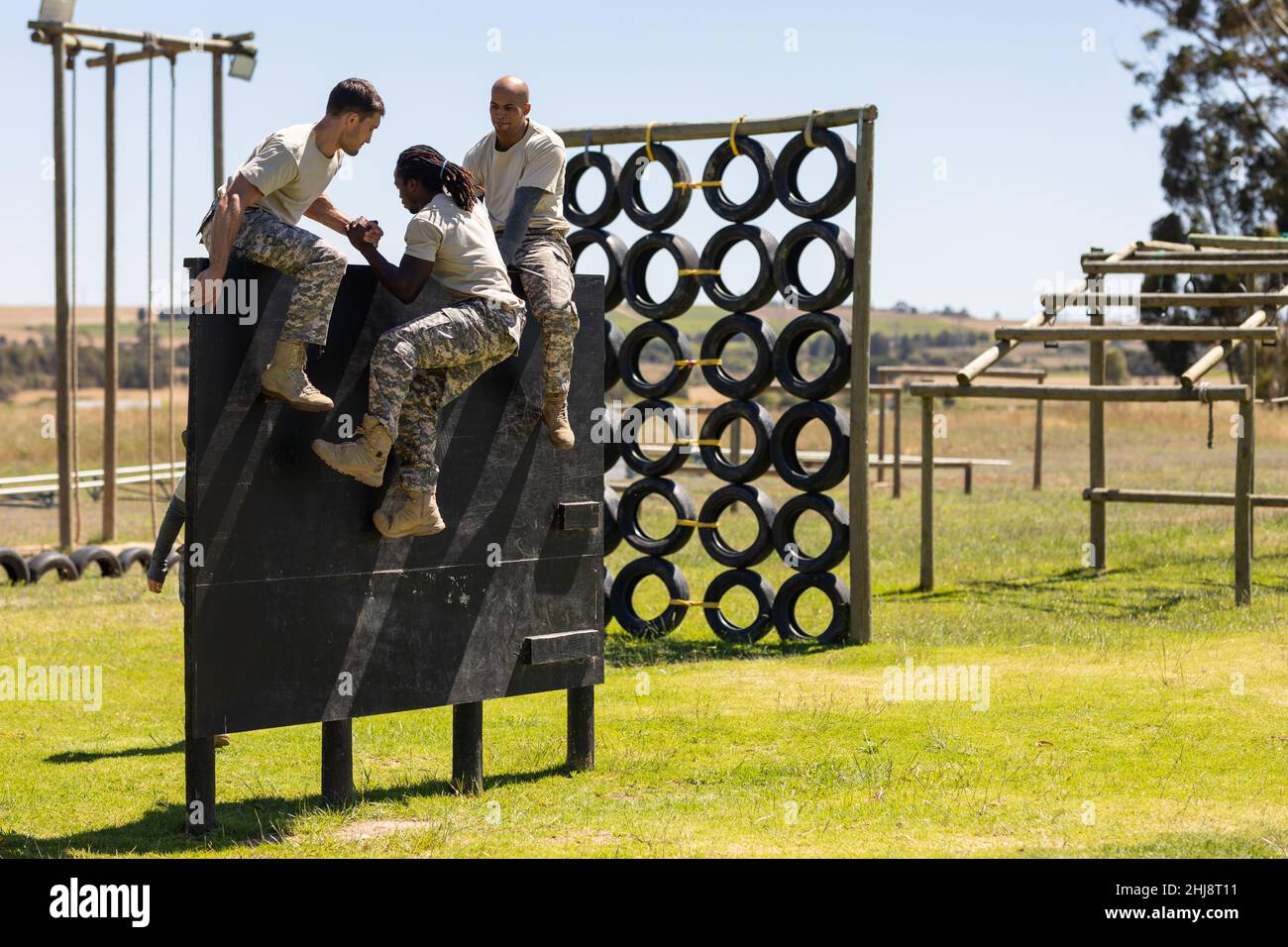 Two diverse male soldiers helping male african american soldier to ...