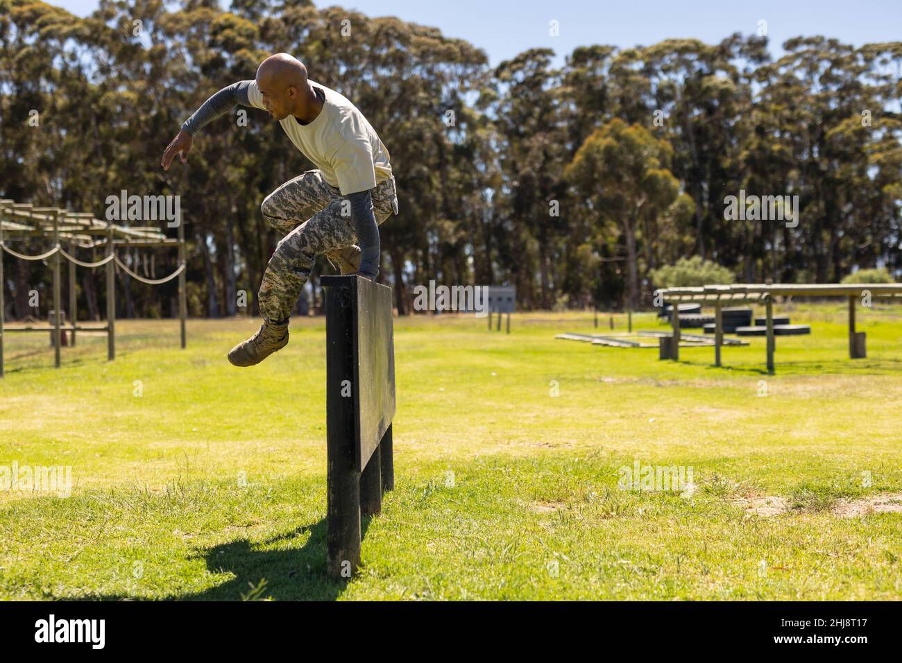 Male african american soldier climbing wooden wall during obstacle ...