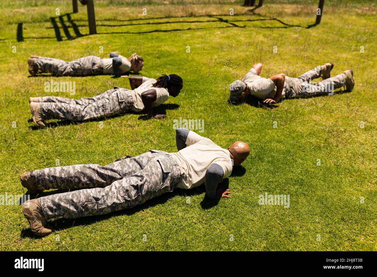 Group of male and female diverse soldiers performing push ups together ...