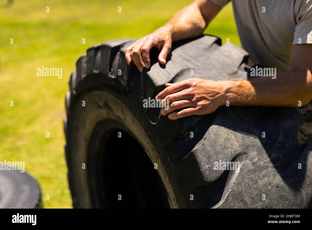 Mid section of a male soldier holding a tire at boot camp Stock Photo ...