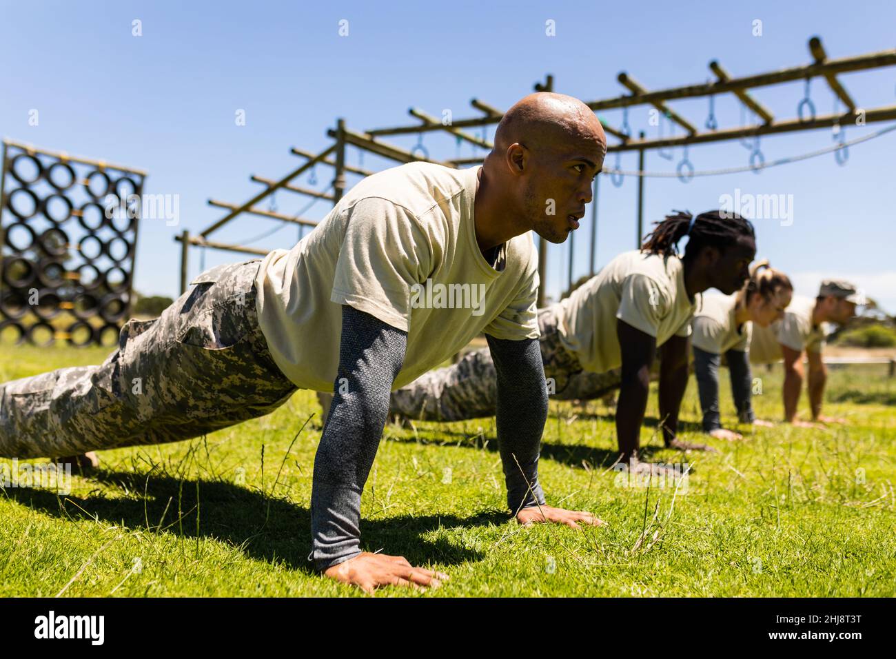 Group of male and female diverse soldiers performing push ups together ...