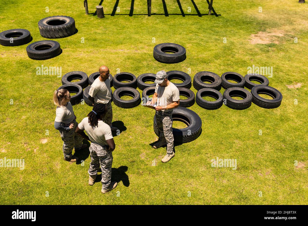 Male instructor with clipboard instructing group of male and female ...