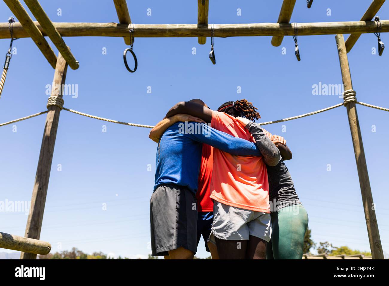 Group of diverse male and female fit people forming huddle at boot camp ...