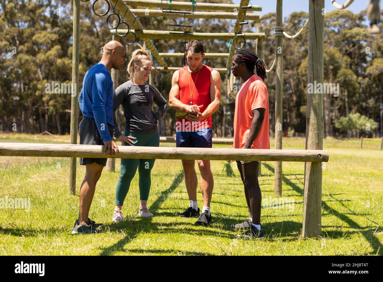 Caucasian male instructor instructing group of male and female fit ...