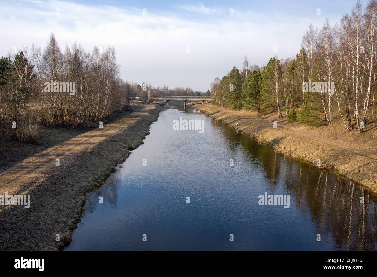 View of a small river with a bridge in spring. Channel of the Vileyka ...