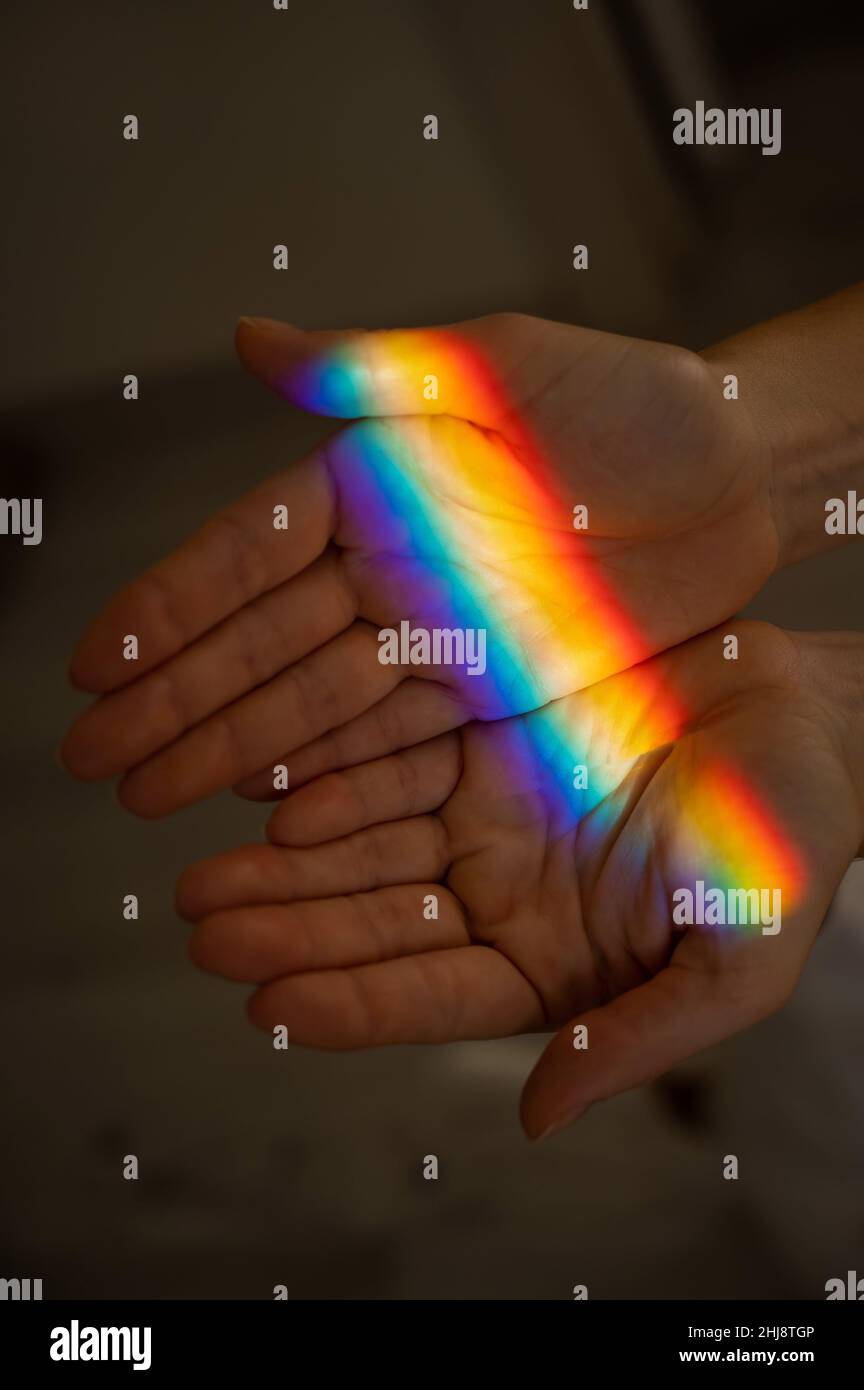 Rainbow ray on a woman's hand Stock Photo - Alamy