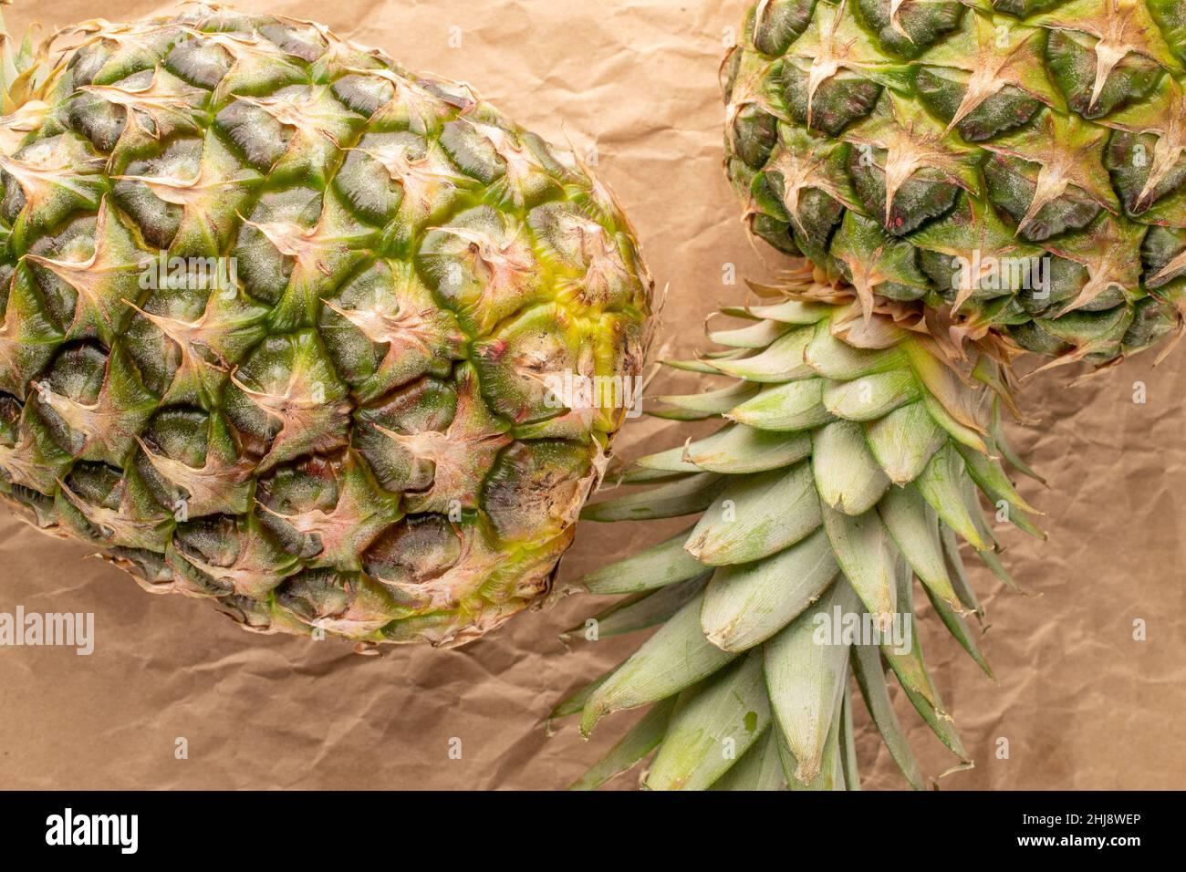 Two organic juicy pineapples on brown paper, close-up, top view Stock Photo - Alamy