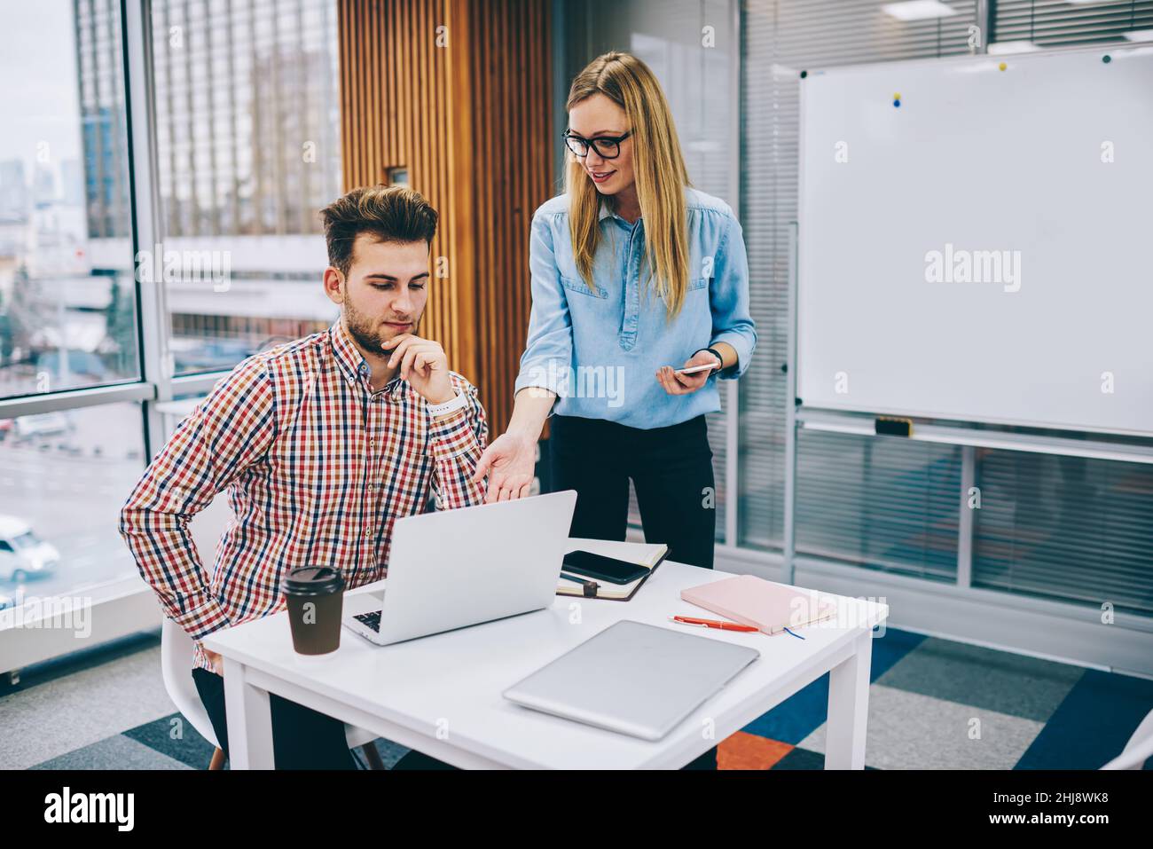 Colleagues discussing new project in office Stock Photo - Alamy