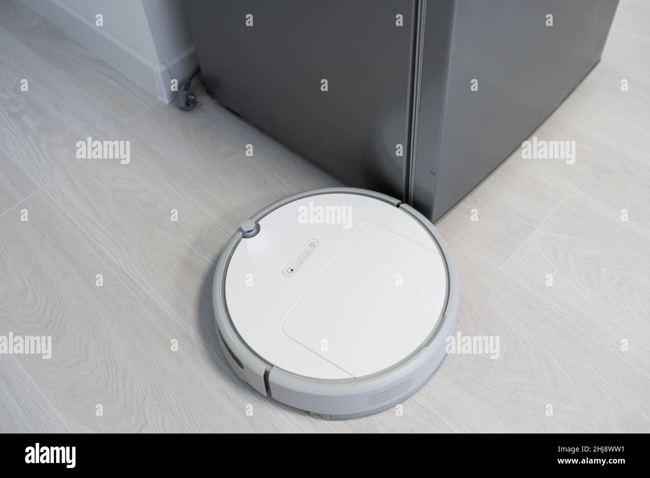 Robot vacuum cleaner cleaning kitchen floor Stock Photo - Alamy